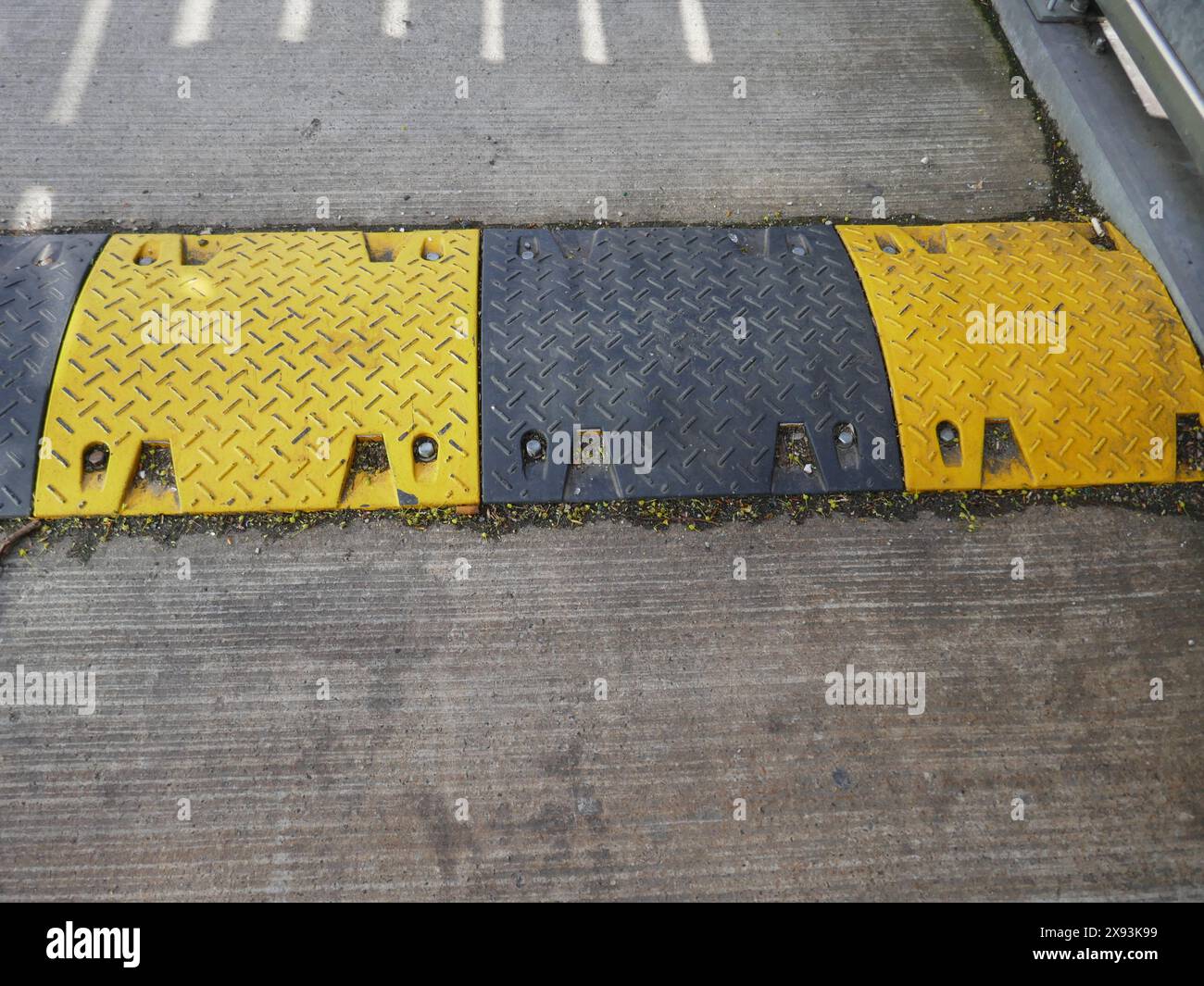 Speed bump painted black and yellow on road Stock Photo - Alamy