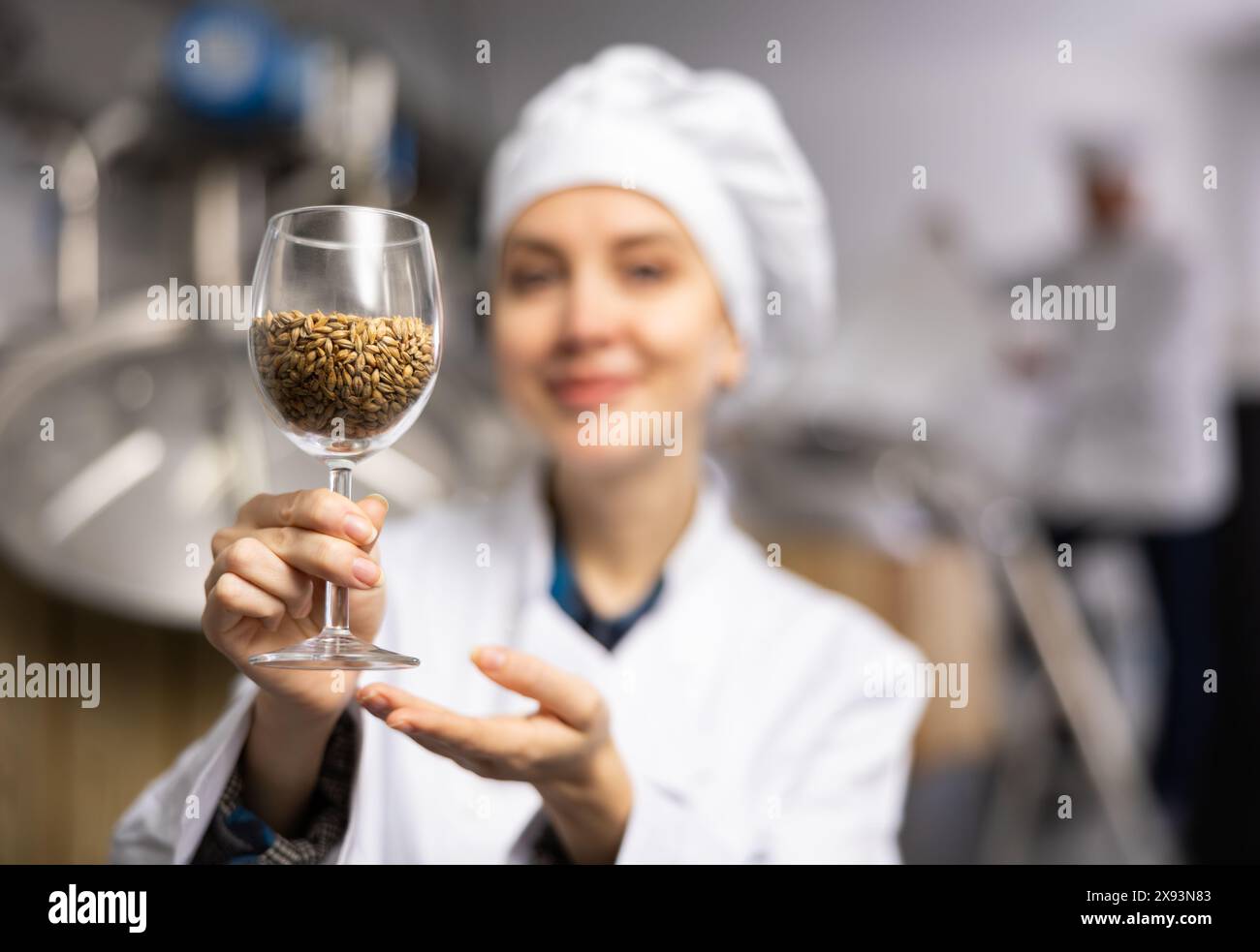 Female brewmaster holding glass of malt Stock Photo - Alamy