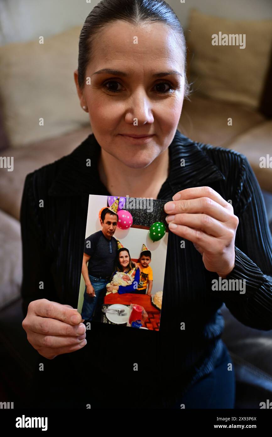 Isabel Valencia holds a photo of her family in her home in Pueblo, Colo ...