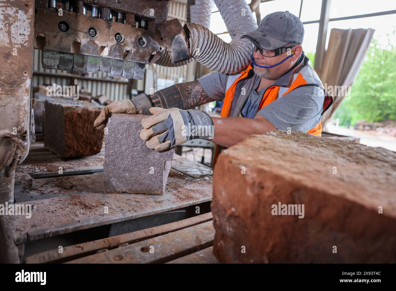 Mittweida, Germany. 28th May, 2024. An employee of Natursteinwerk ...