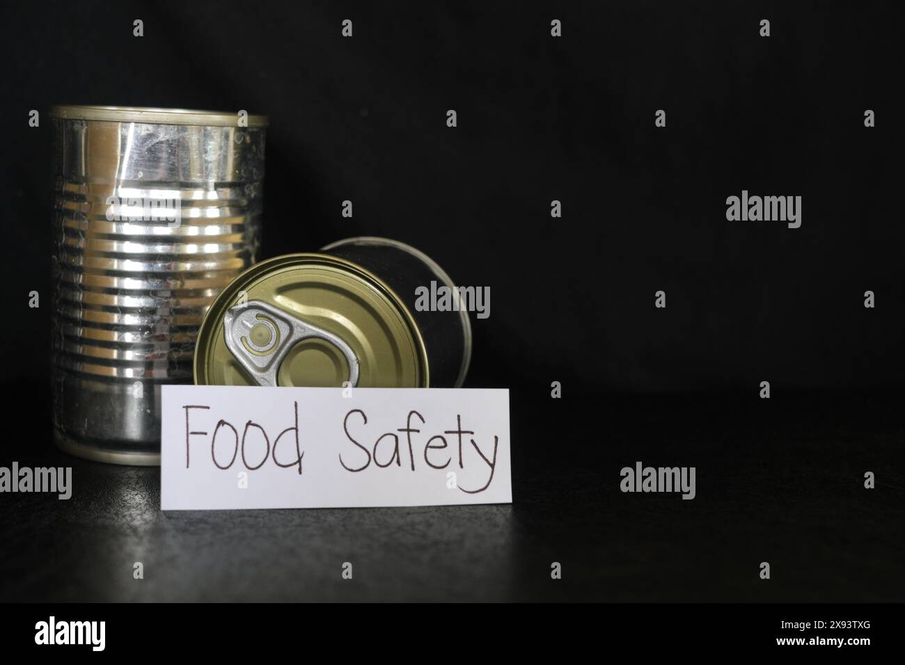 Food safety concept. Labeled canned food in dark black background Stock ...