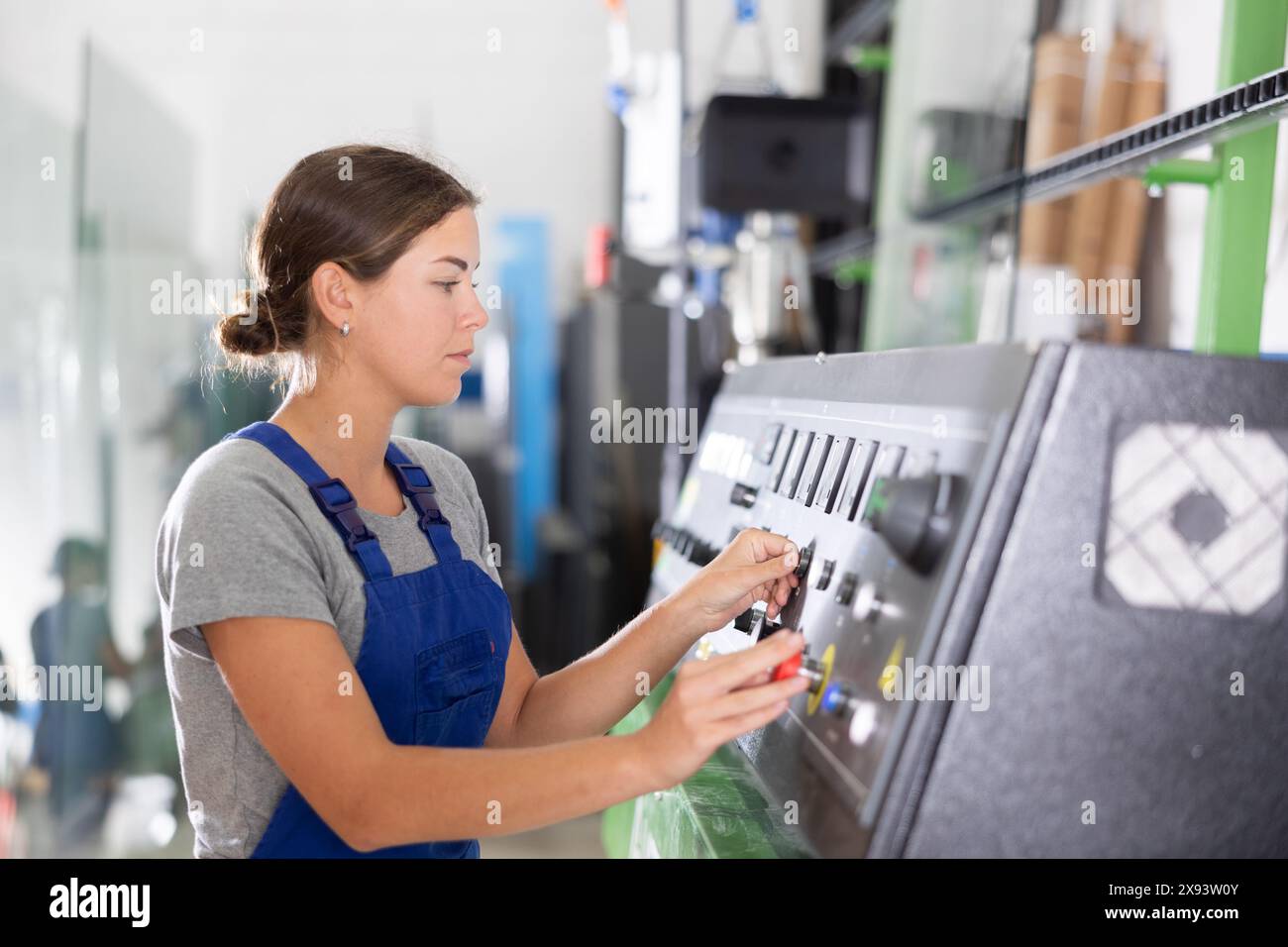 Glass factory worker at workplace with control panel, controlling ...