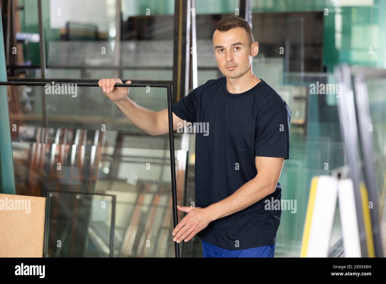 Technician inspecting insulated glass units stacked in workshop Stock ...
