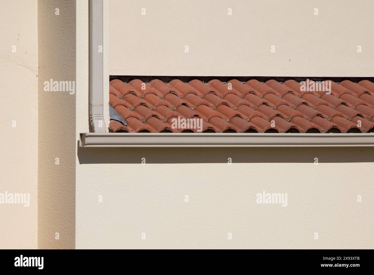 aluminum beige gutter on modern roof of the building and downpipe on ...