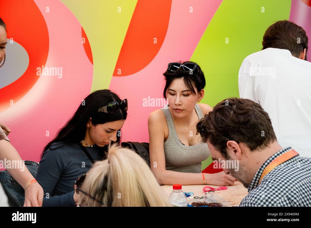 Conference visitors take part in the Adobe hands-on creative table making physical designs at ...
