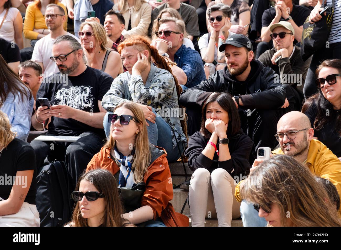 Attendees sat outside in the sunshine watch talks from the Open Room ...
