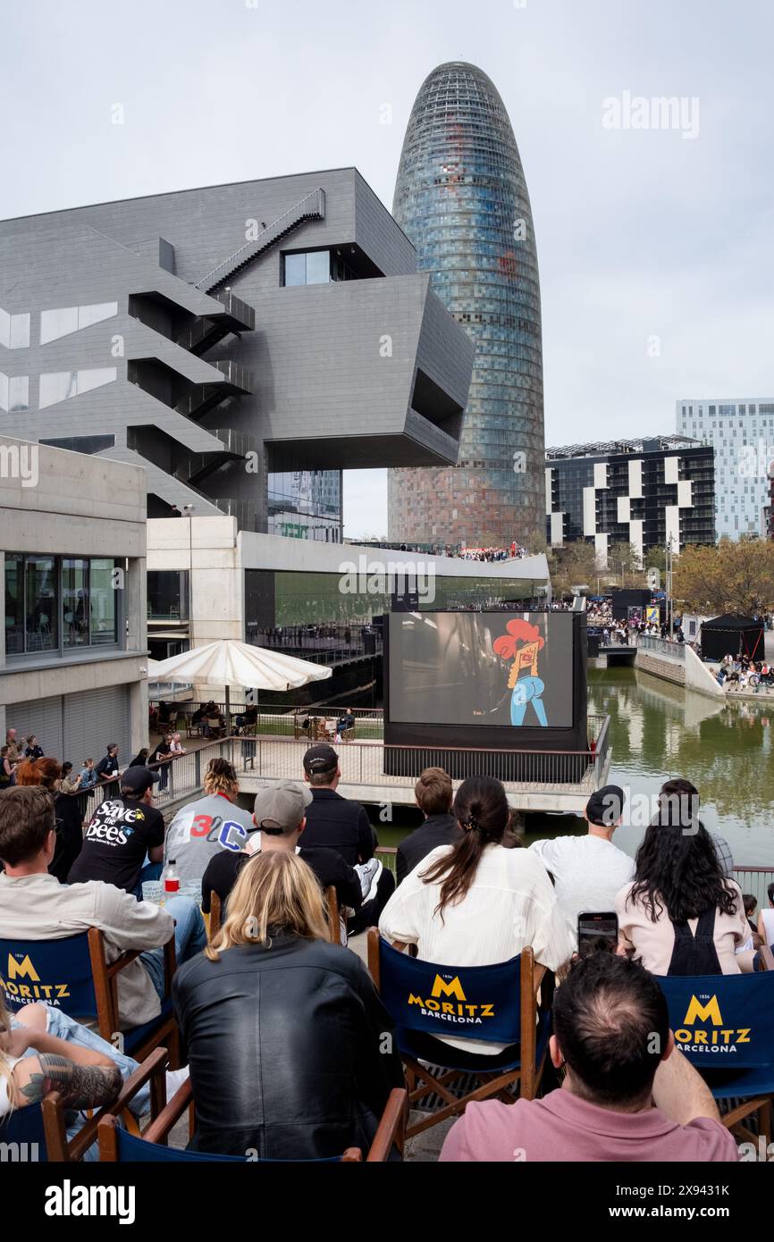 Attendees sat outside in the sunshine watch talks from the Open Room ...