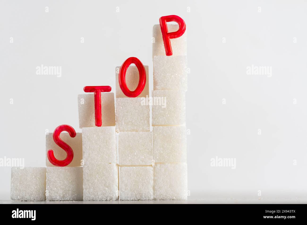 Ladder made refined sugar cubes with inscription stop on white ...