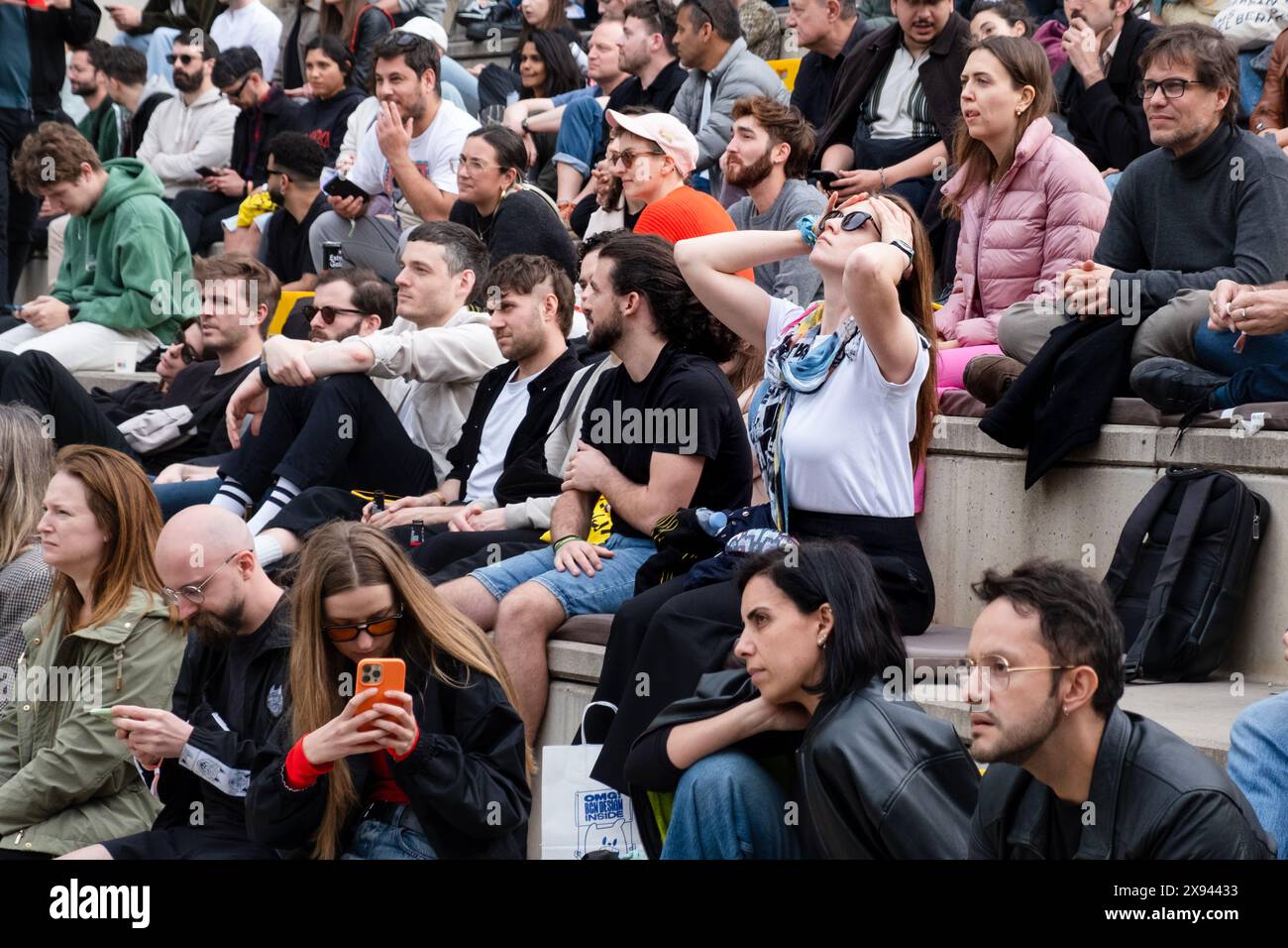Attendees sat outside in the sunshine watch talks from the Open Room ...