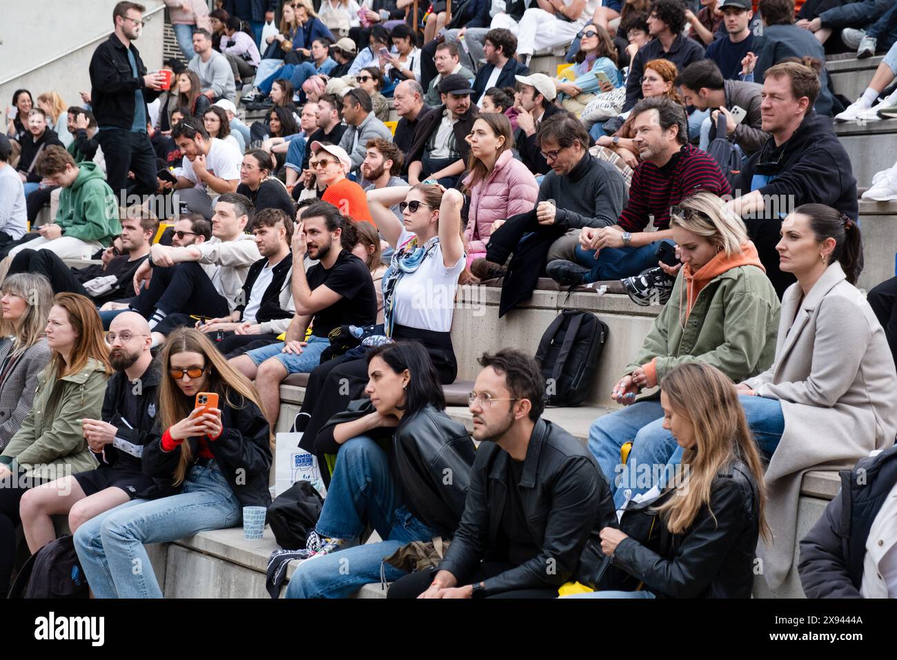 Attendees sat outside in the sunshine watch talks from the Open Room ...