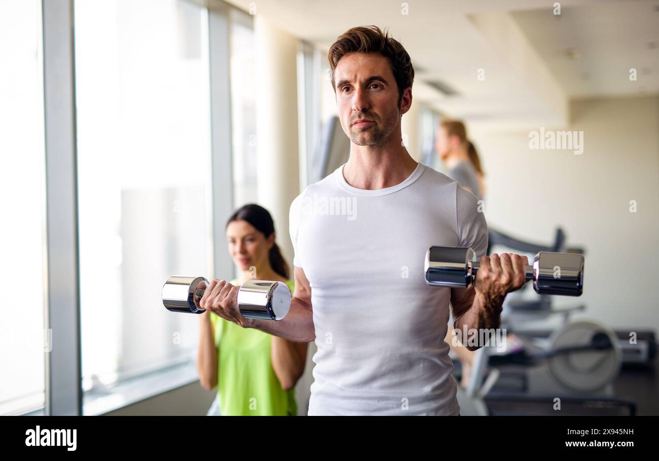 Group of young people doing exercises in gym to stay healthy. Sport gym ...