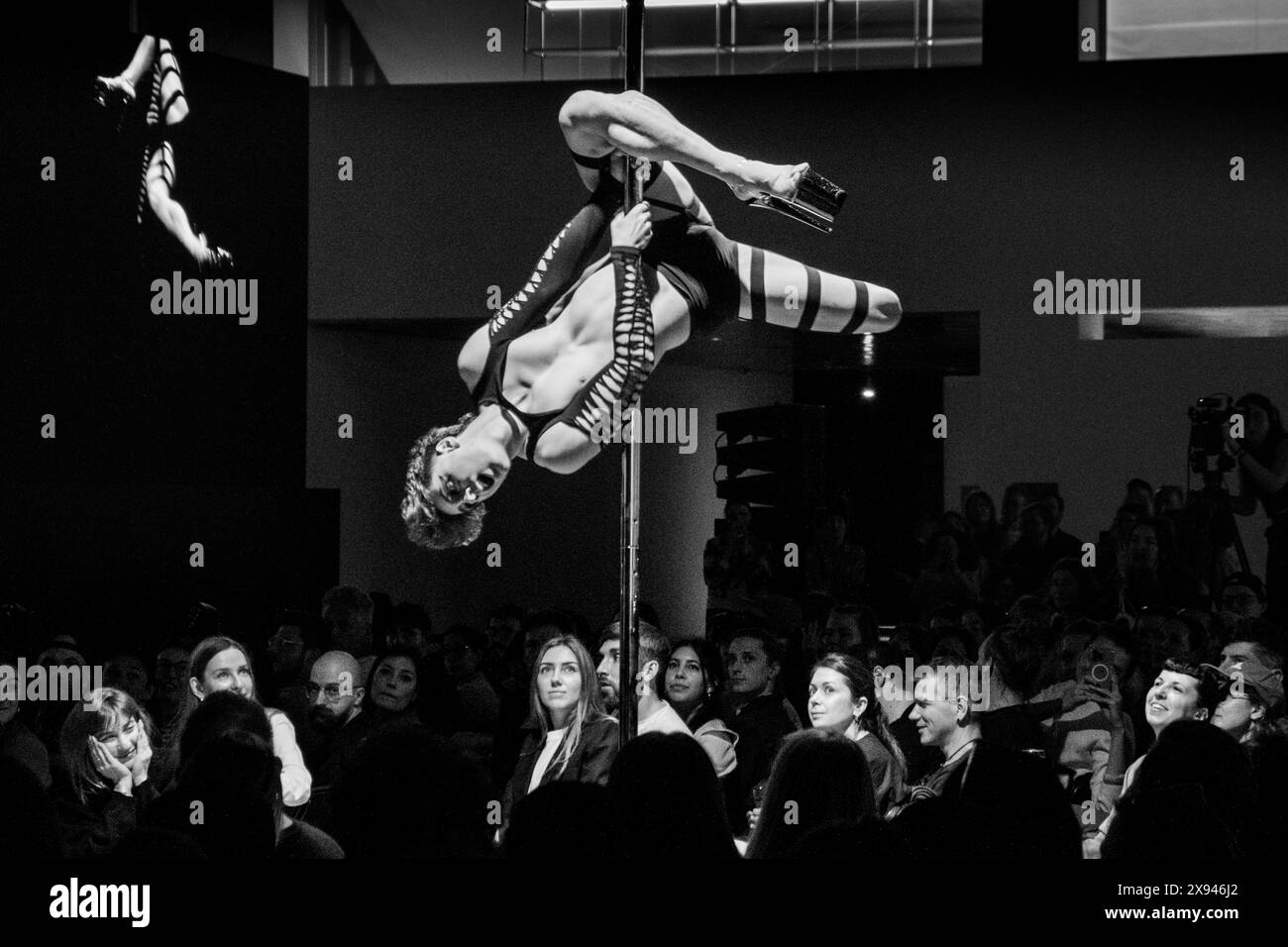 A leather clad male pole dancer performs in the centre of the corwd as ...