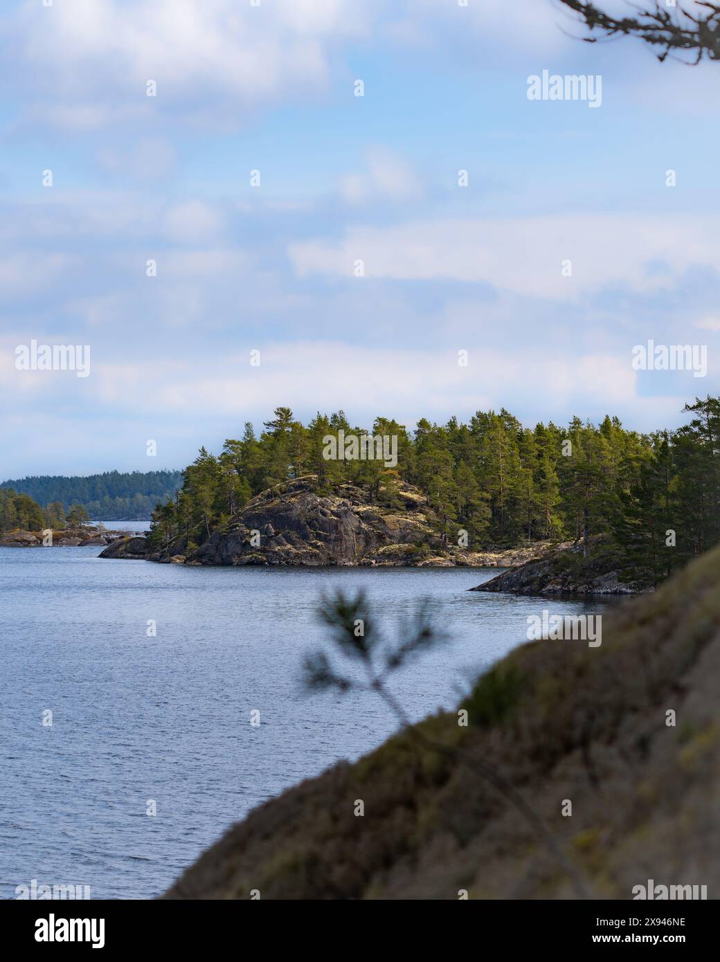 A scenic view of a calm lake surrounded by lush greenery and rocky ...
