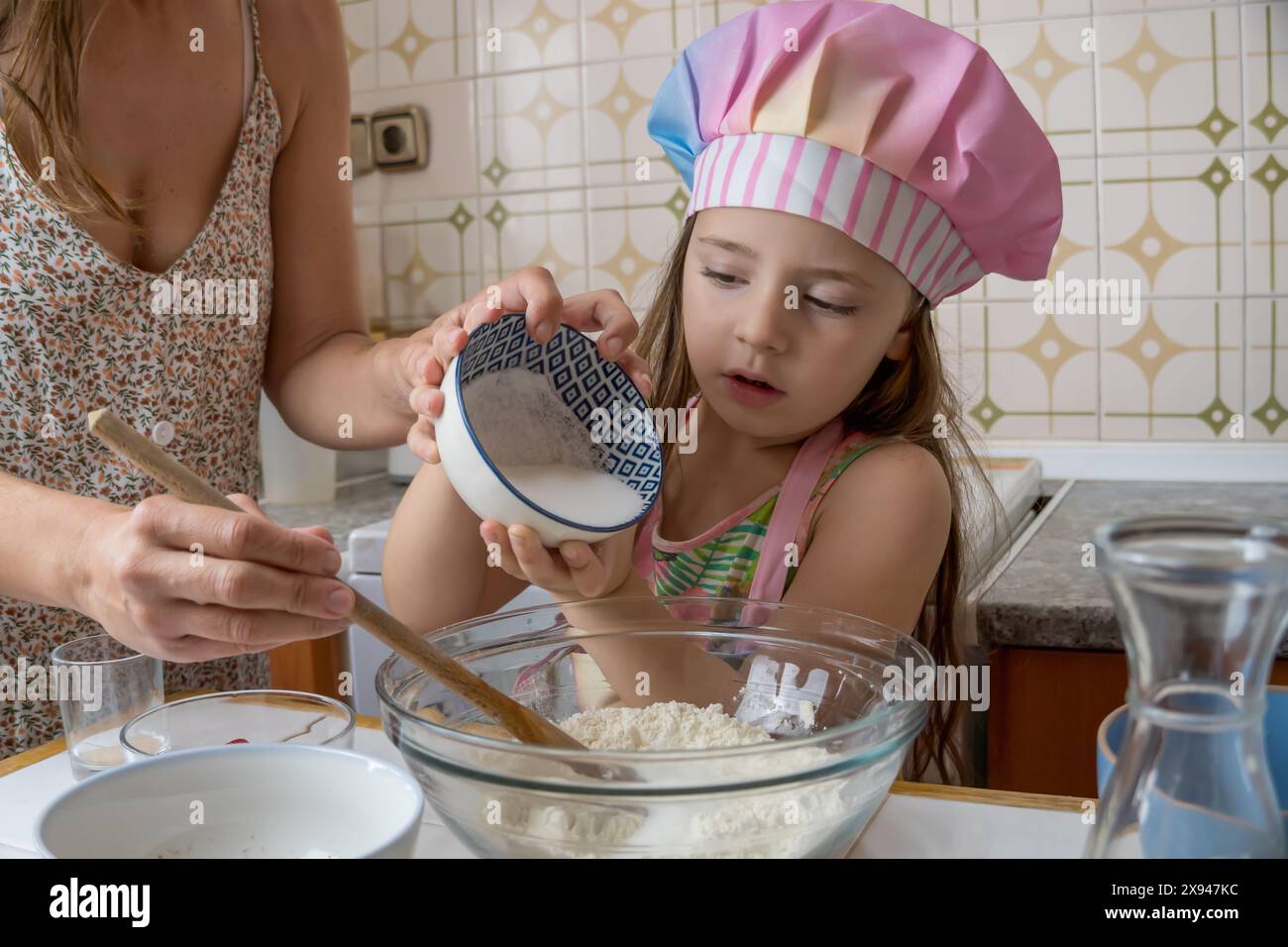 a girl dressed as a cook enjoying an afternoon of cooking with her ...