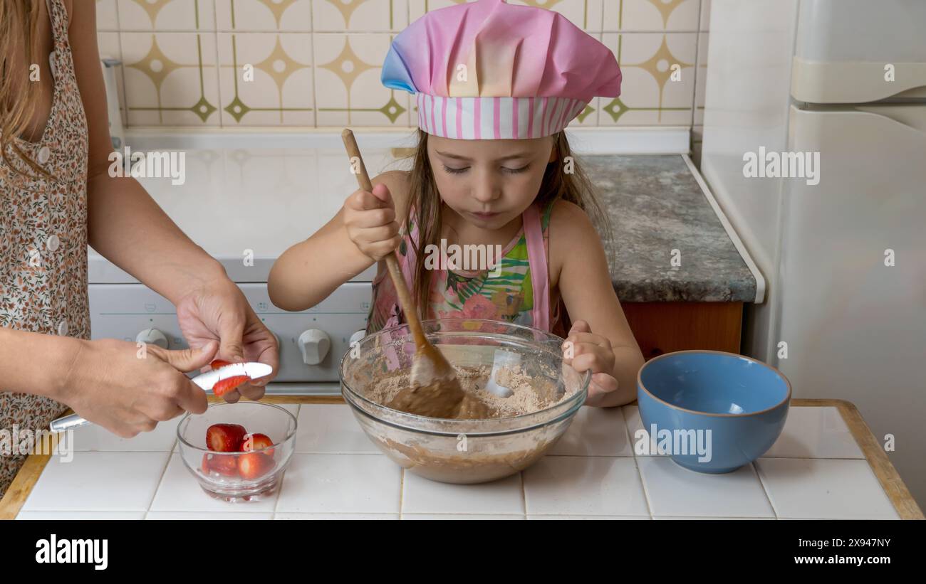 a girl dressed as a cook enjoying an afternoon of cooking with her ...