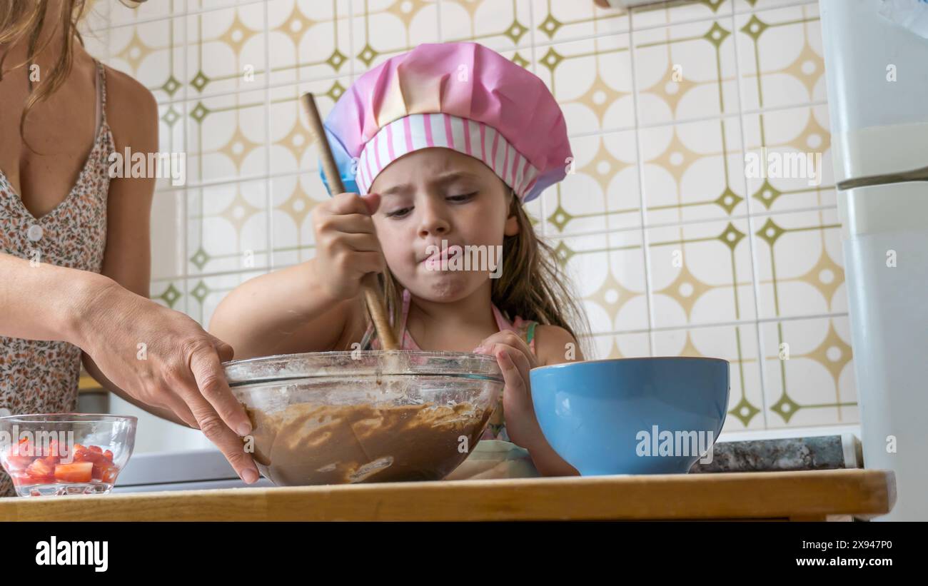 a girl dressed as a cook enjoying an afternoon of cooking with her ...