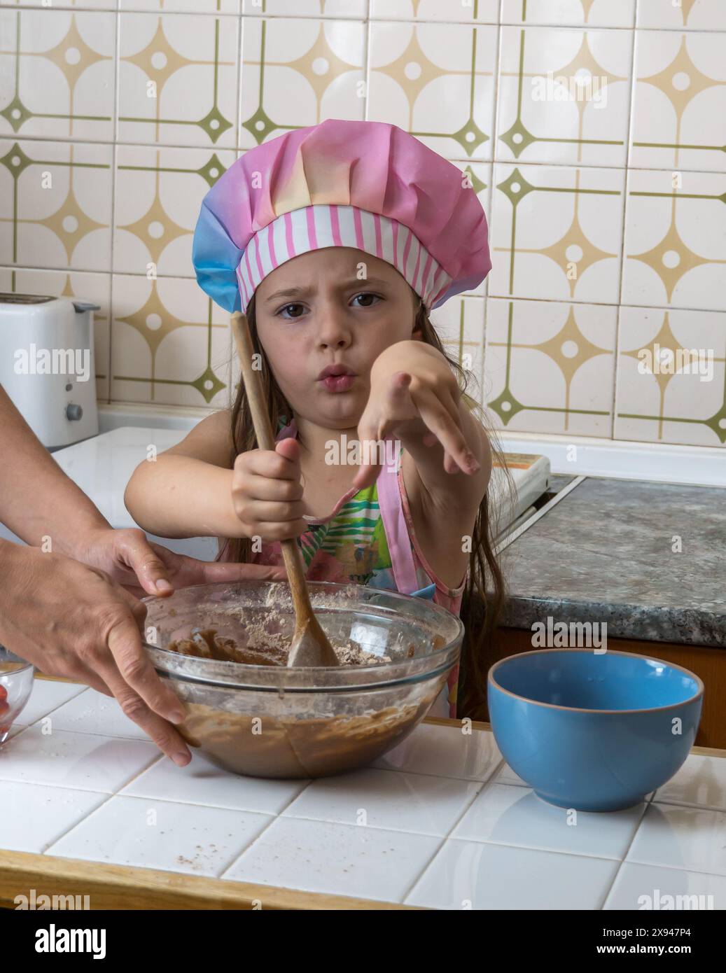 a girl dressed as a cook enjoying an afternoon of cooking with her ...