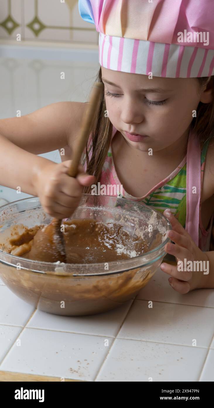 a girl dressed as a cook enjoying an afternoon of cooking with her ...