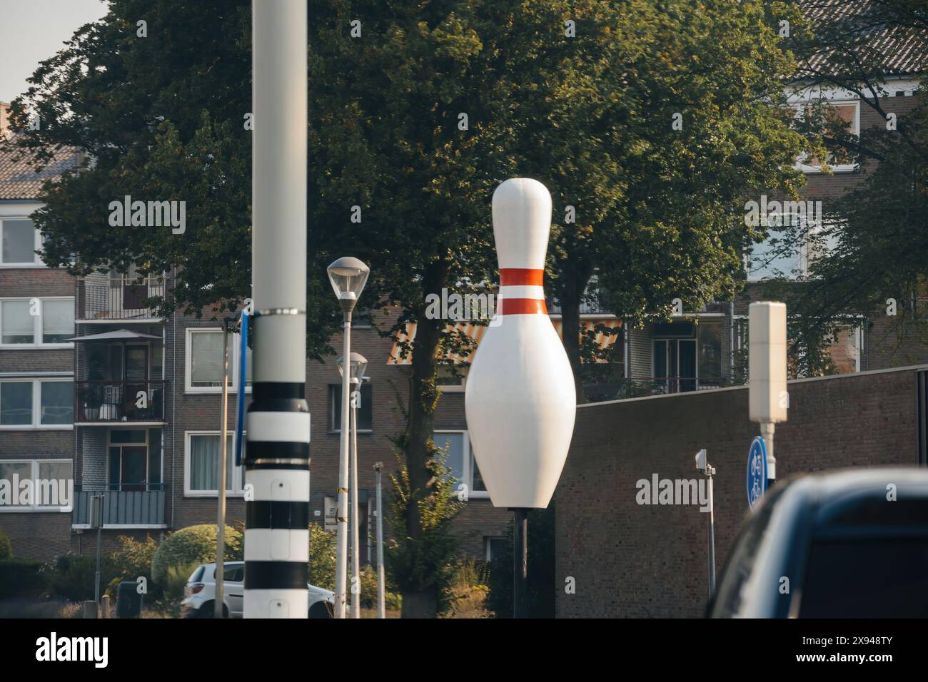A large bowling pin sculpture stands prominently on a street in the ...
