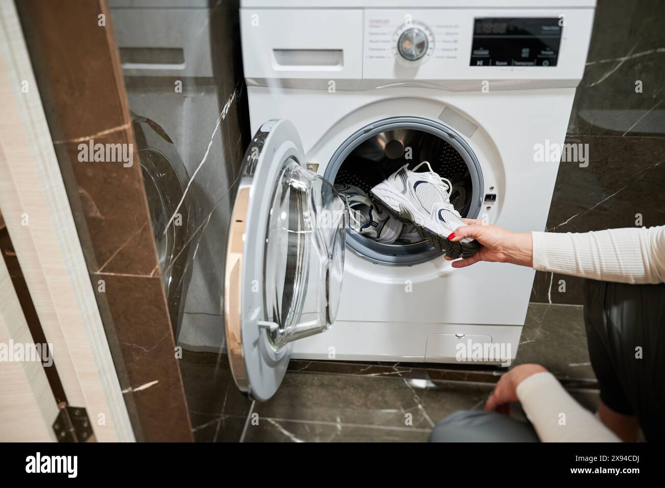 Dirty sport shoes need to be washed. Cropped photo of woman putting ...
