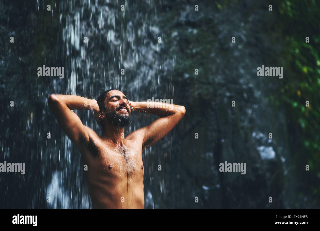 Man, waterfall and happy in nature on travel trip, eyes closed and ...