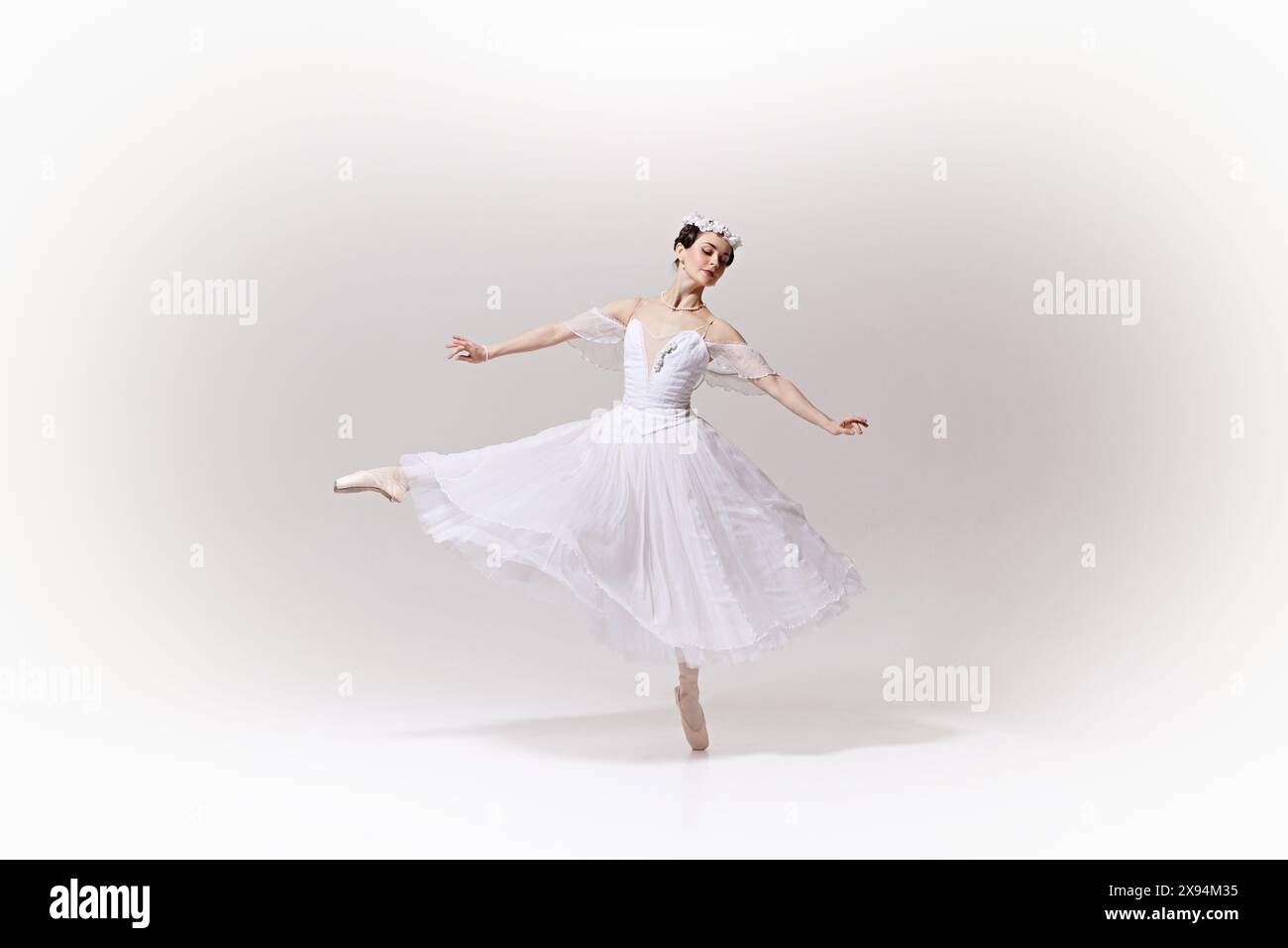 Portrait of graceful ballerina in flowing white dress, looks as ...