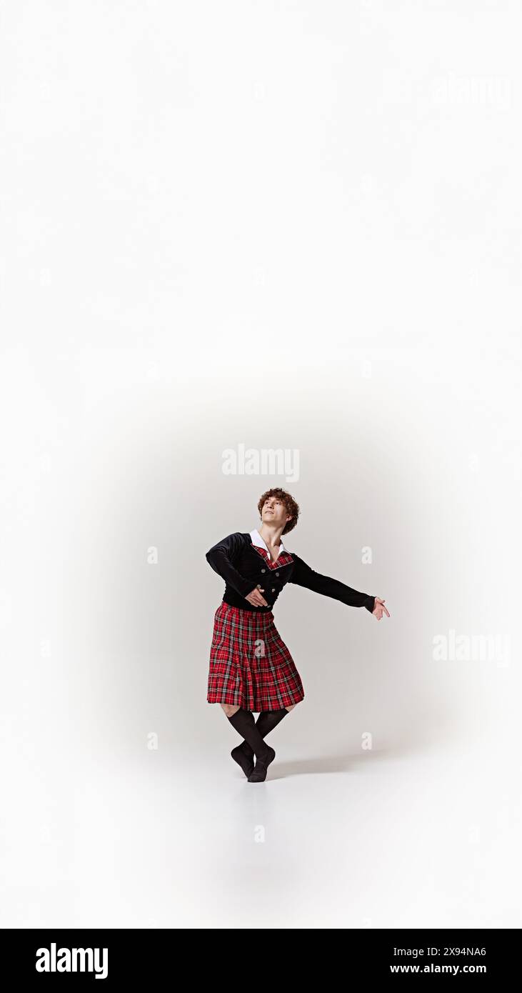 Poster. Wearing red plaid kilt and dark jacket, ballet dancer holds ...