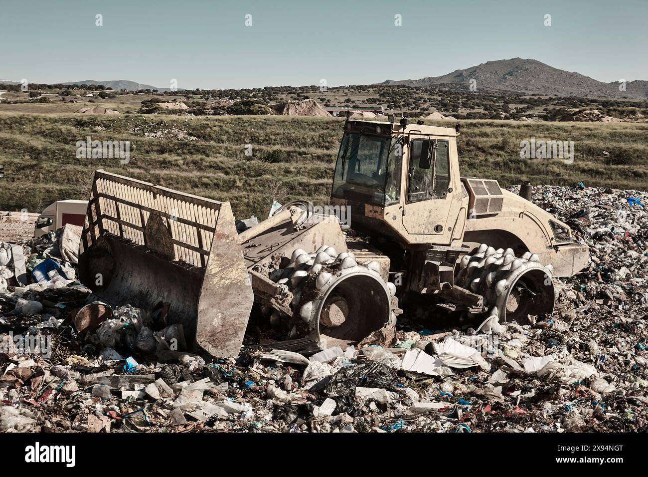 Heavy machinery shredding garbage in an open air landfill. Waste Stock ...