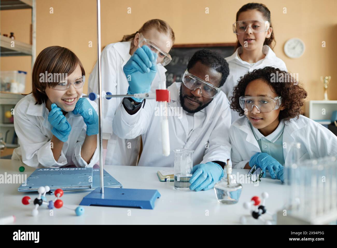 Young African American teacher of Chemistry sitting at table in ...
