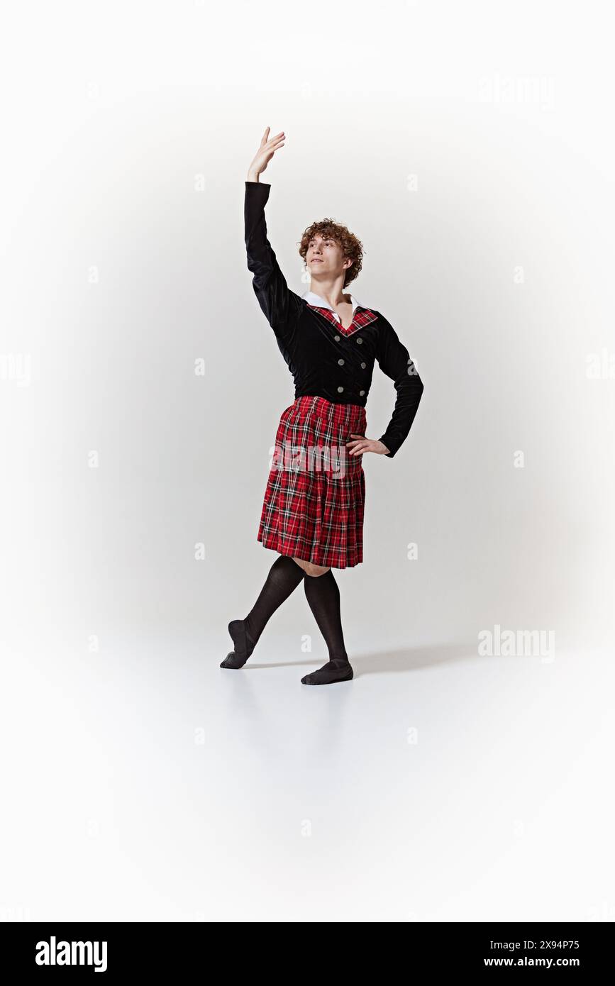 Portrait of ballet dancer wearing traditional attire and raised arm ...