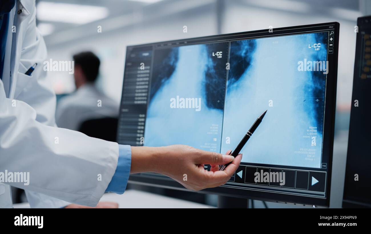 Medical Hospital: Two Doctors Talk and Use Computer, Point at Screen ...