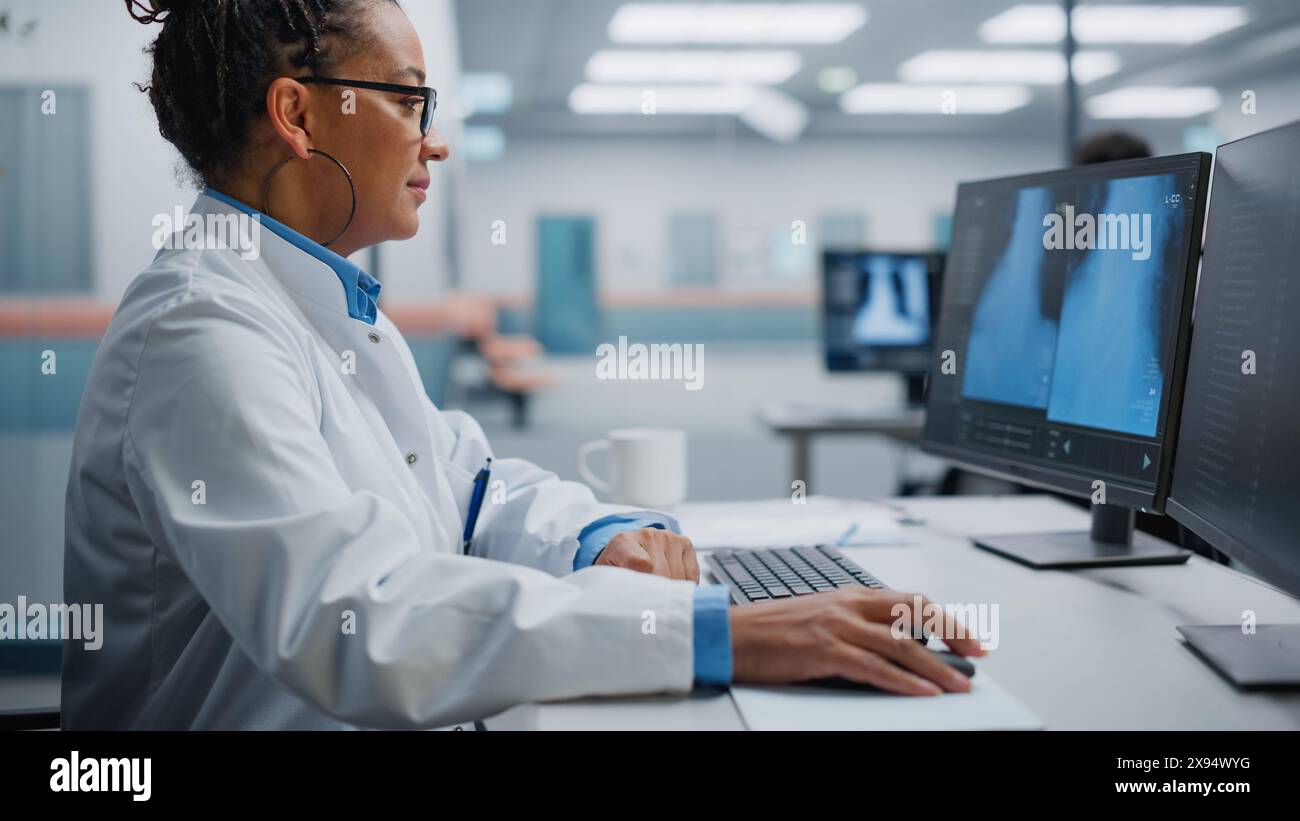 Hospital Laboratory: Black Female Medical Doctor is Working on Computer ...