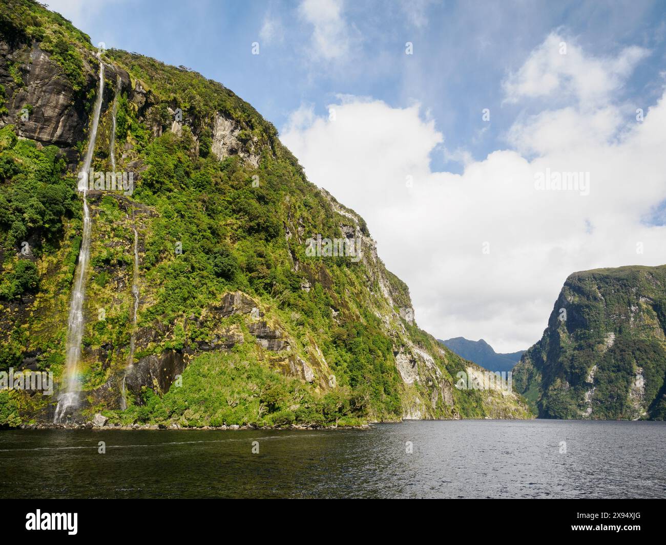 Waterfall off towering cliffs on Doubtful Sound, Fiordland National ...