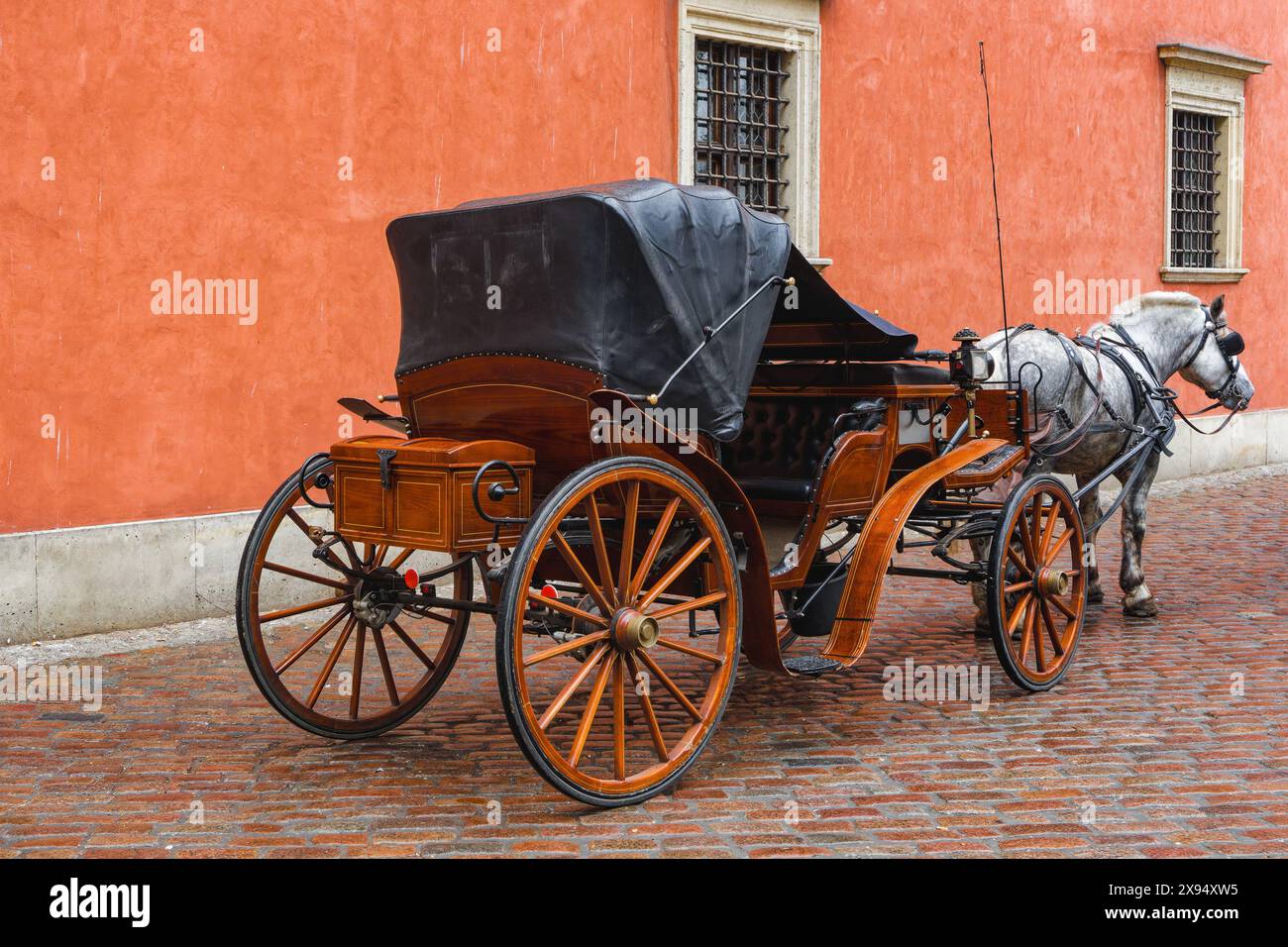 A rustic two-wheeled wooden carriage with suspensions, drawn by a horse ...
