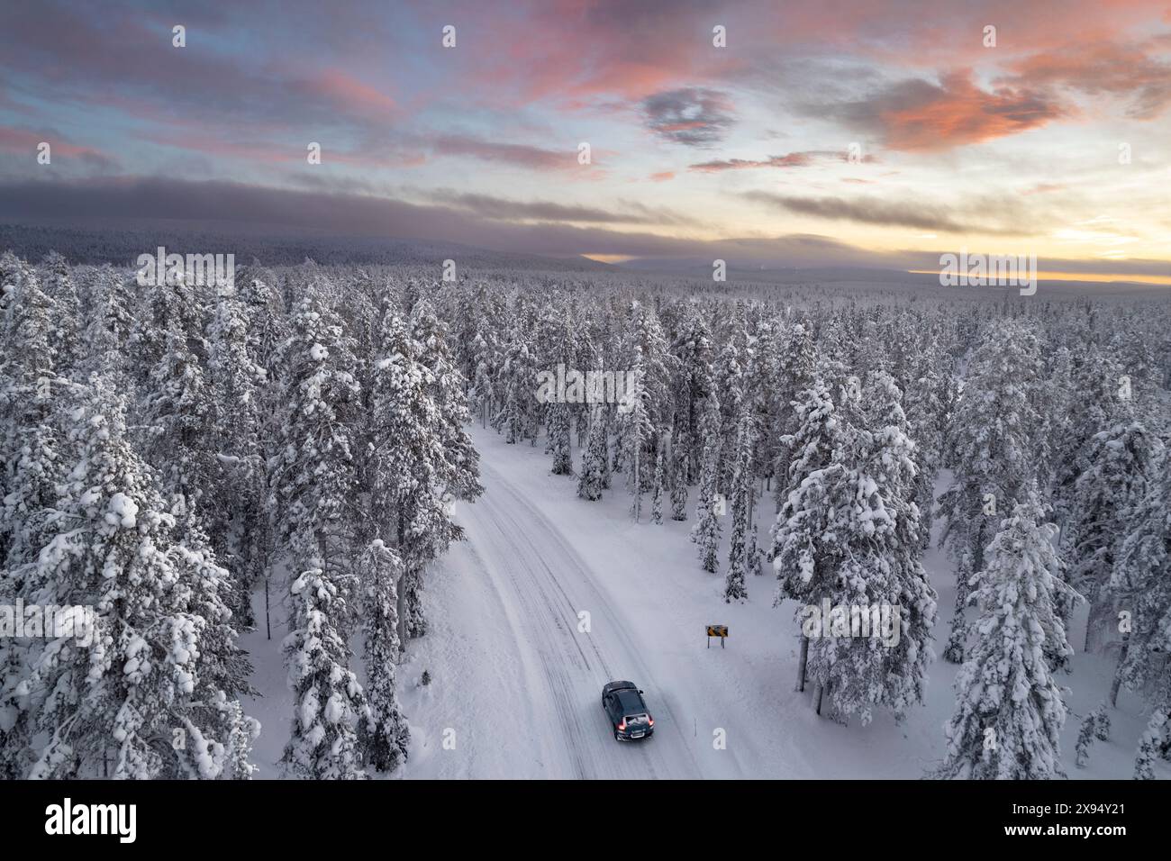 Car driving through the snowy wood in the dramatic winter landscape of ...