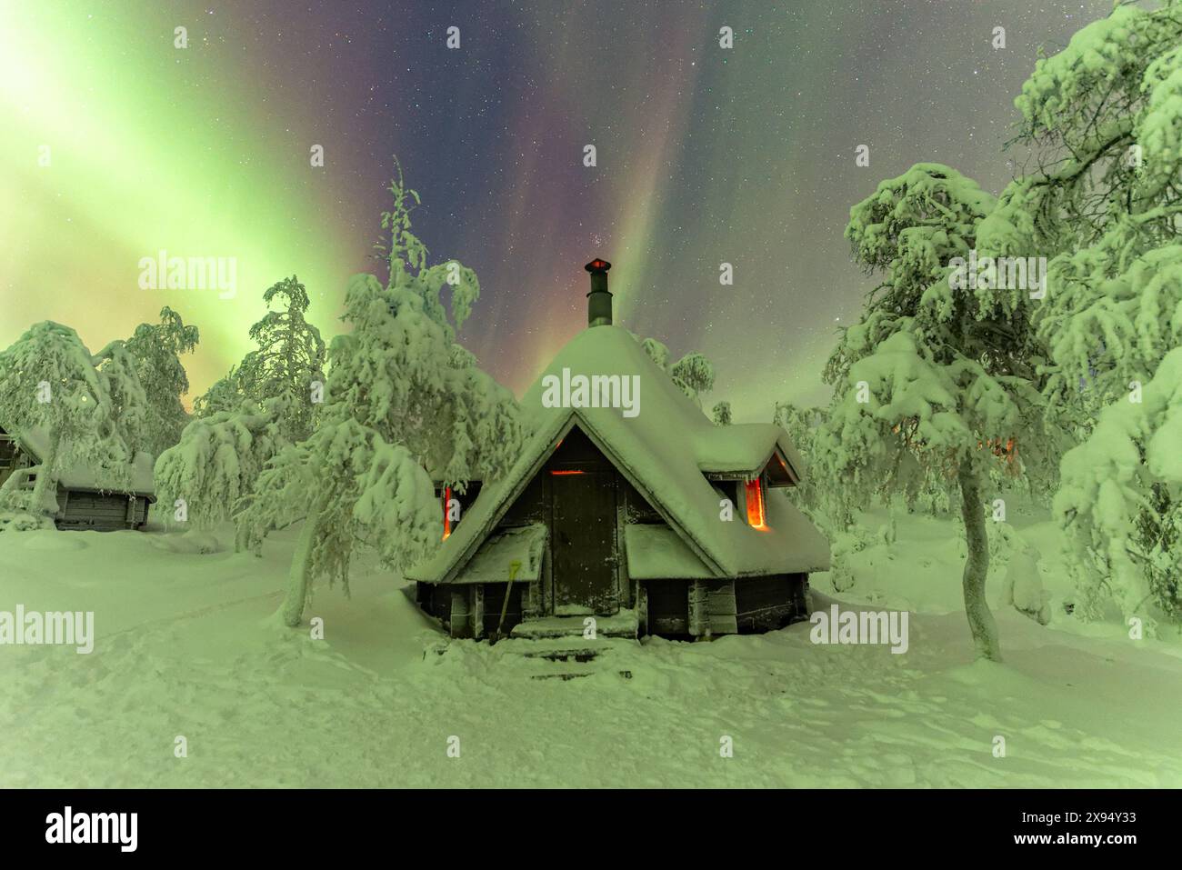 Northern Lights (Aurora Borealis) above a mountain hut in the wood of ...