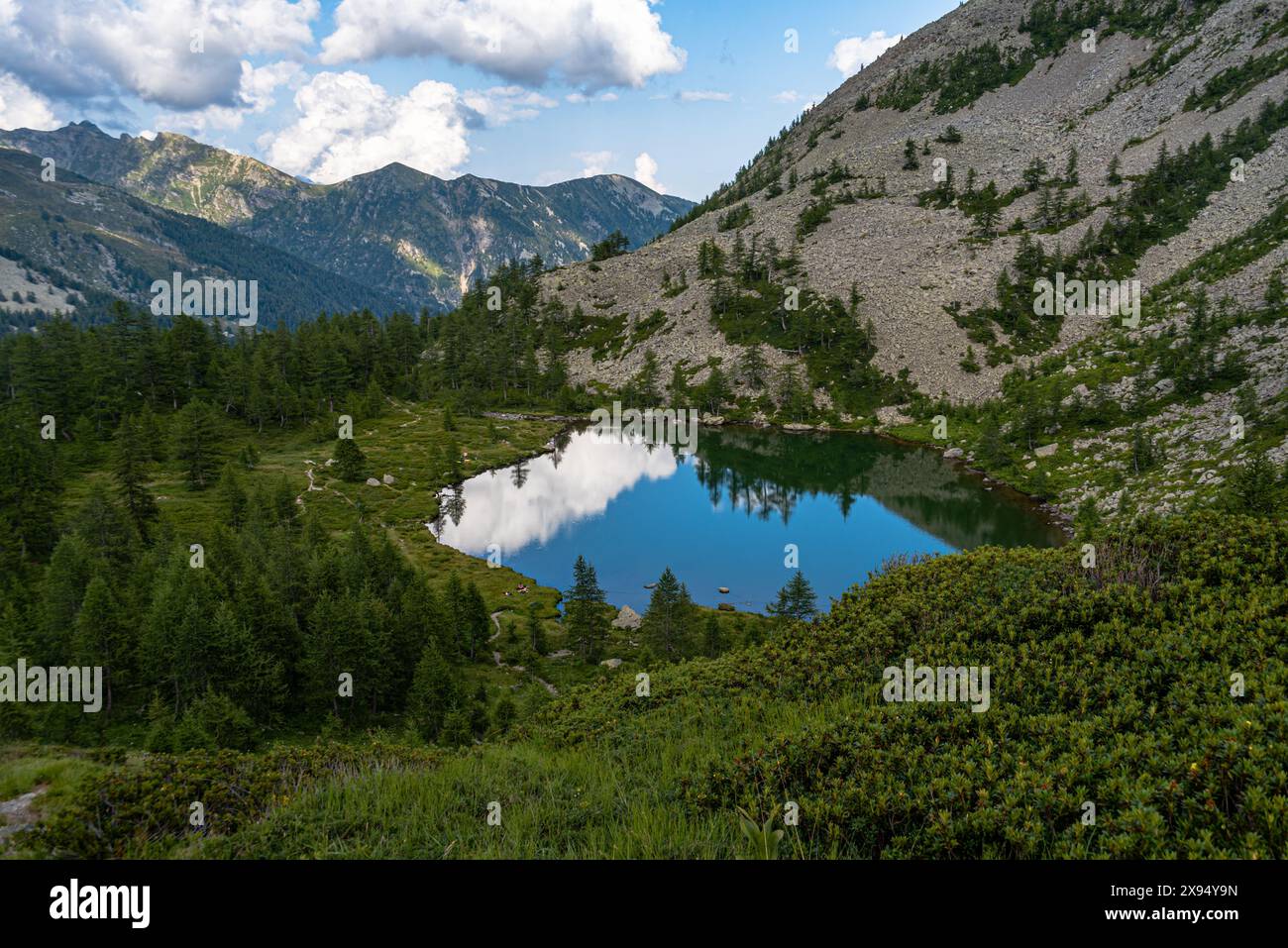 Pristine alpine lake reflecting the blue sky, Alpine Crossing, Italian ...