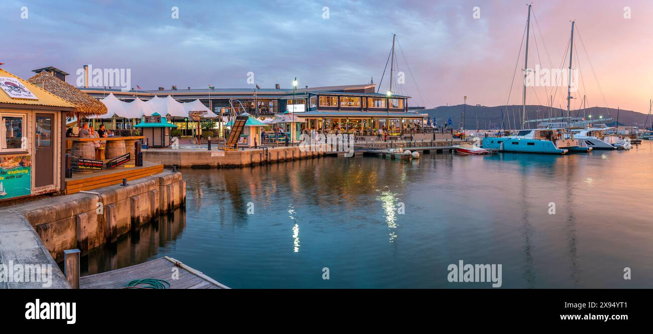 View of golden sunset, boats and restaurants at Knysna Waterfront ...