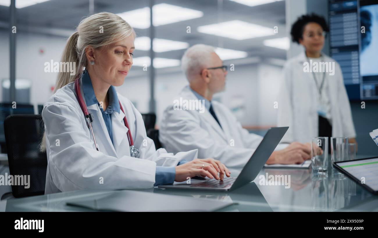 Hospital Conference Meeting Room: Female Physician Works on Laptop ...