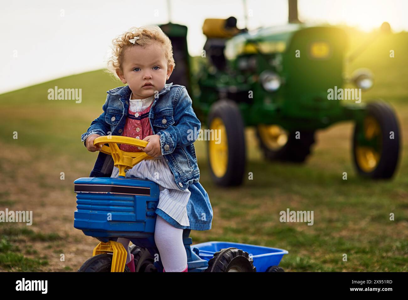 Portrait, kid and driving toy tractor on farm in countryside for ...