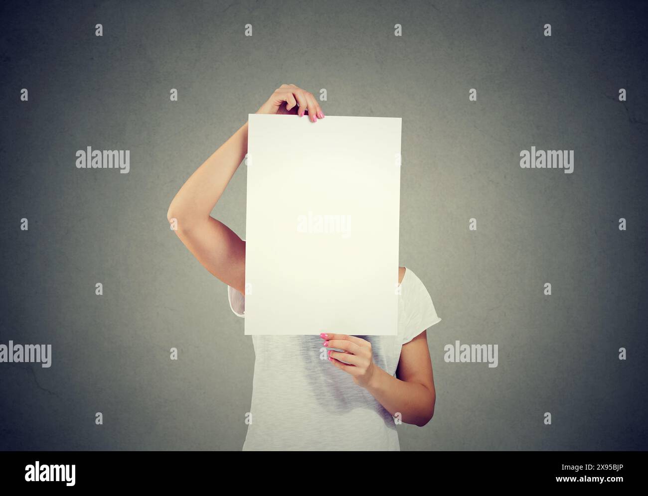 A woman holds a sheet of white paper in front of her face Stock Photo ...