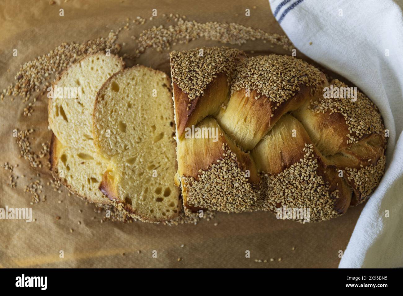Homemade traditional sliced braided Challah bread on baking paper ...