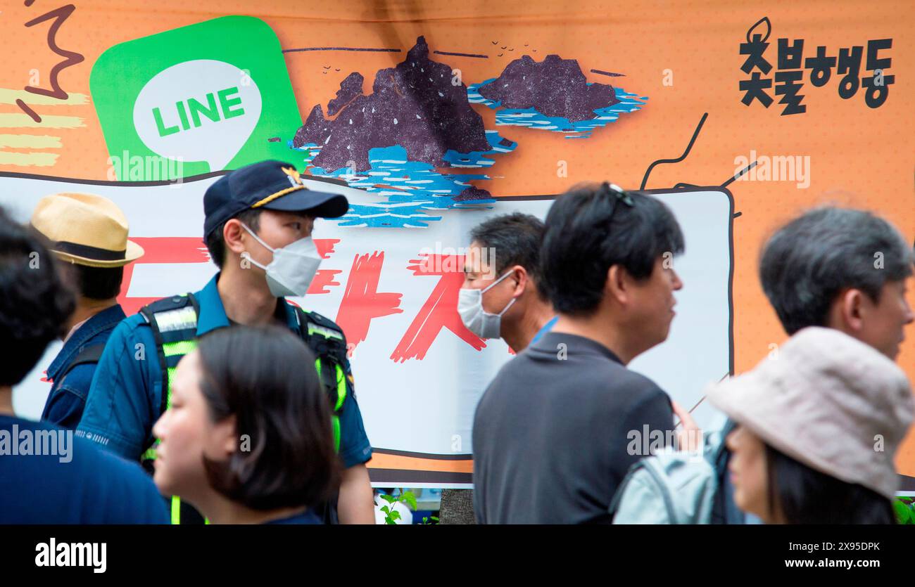 Line messenger app, May 25, 2024 : People walk past a protest placard ...