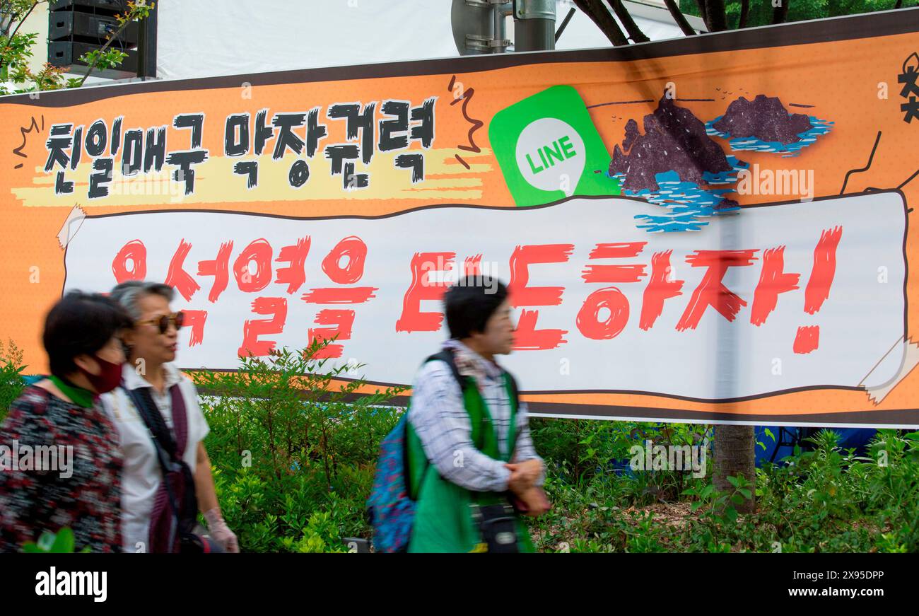 Line messenger app, May 25, 2024 : People walk past a protest placard ...