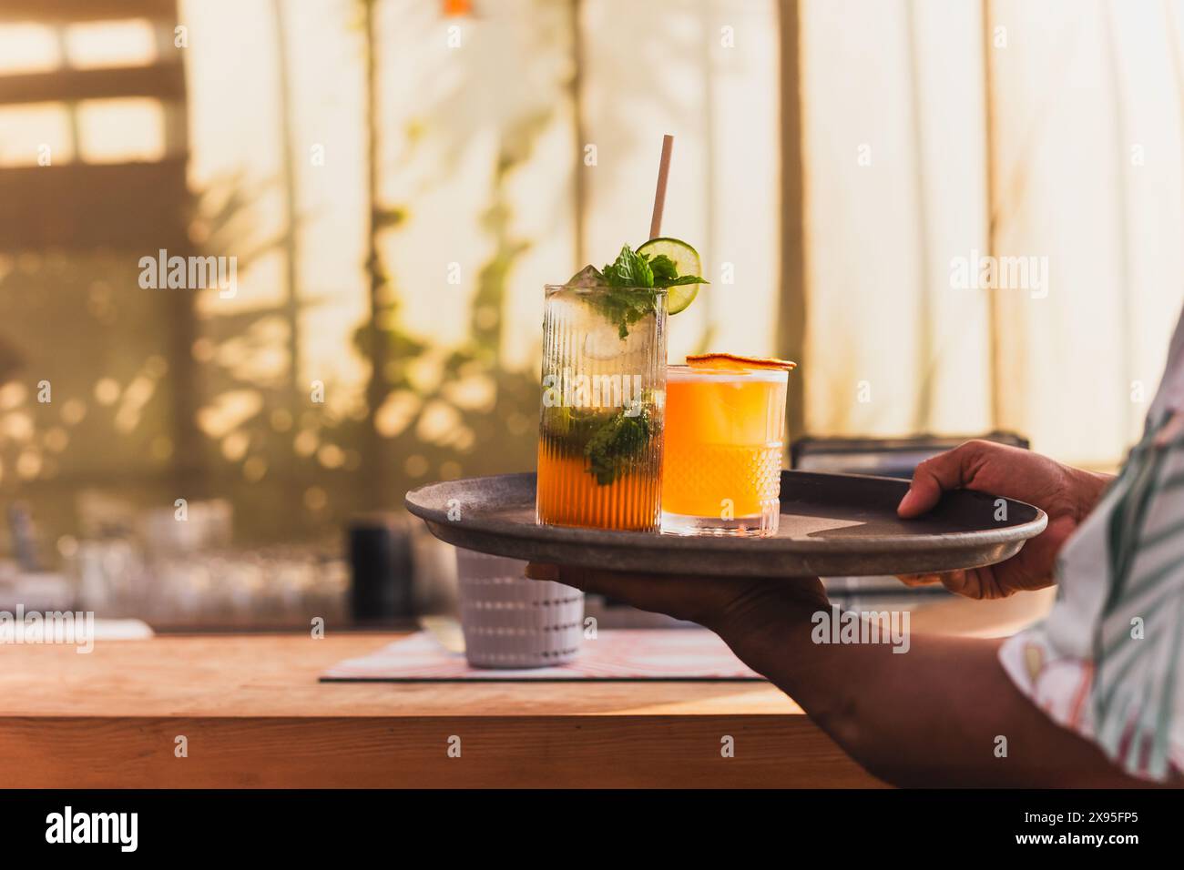 The waiter serving cocktail on a tray Stock Photo - Alamy
