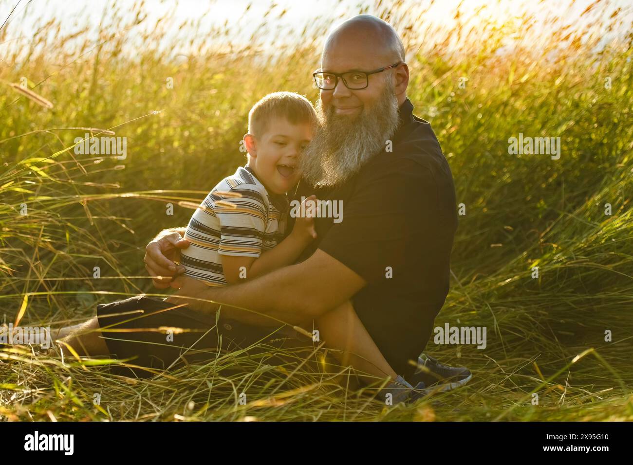 Portrait of a little boy with down syndrome in sunset on summer season ...
