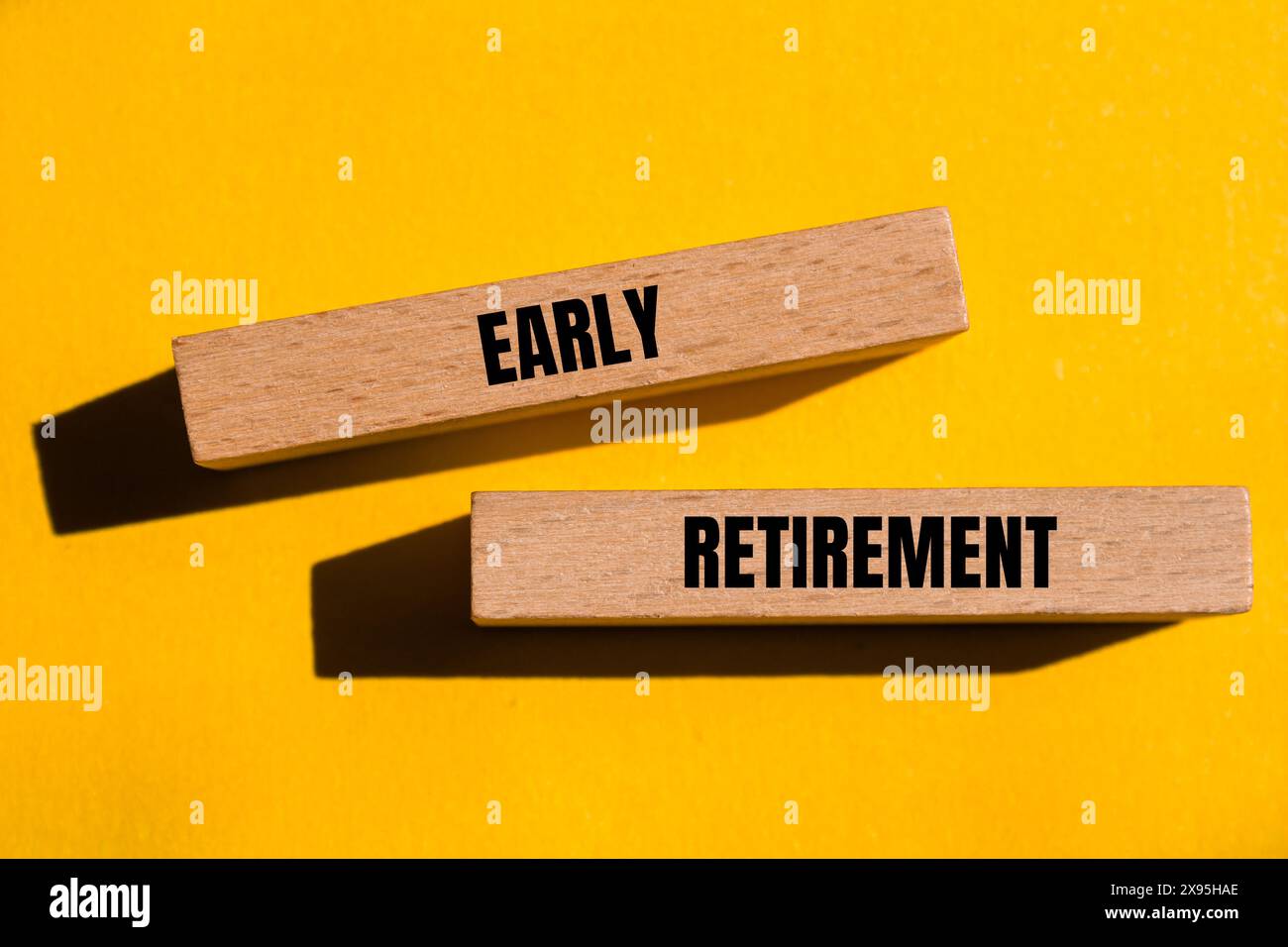 Early retirement words written on wooden blocks with yellow background ...