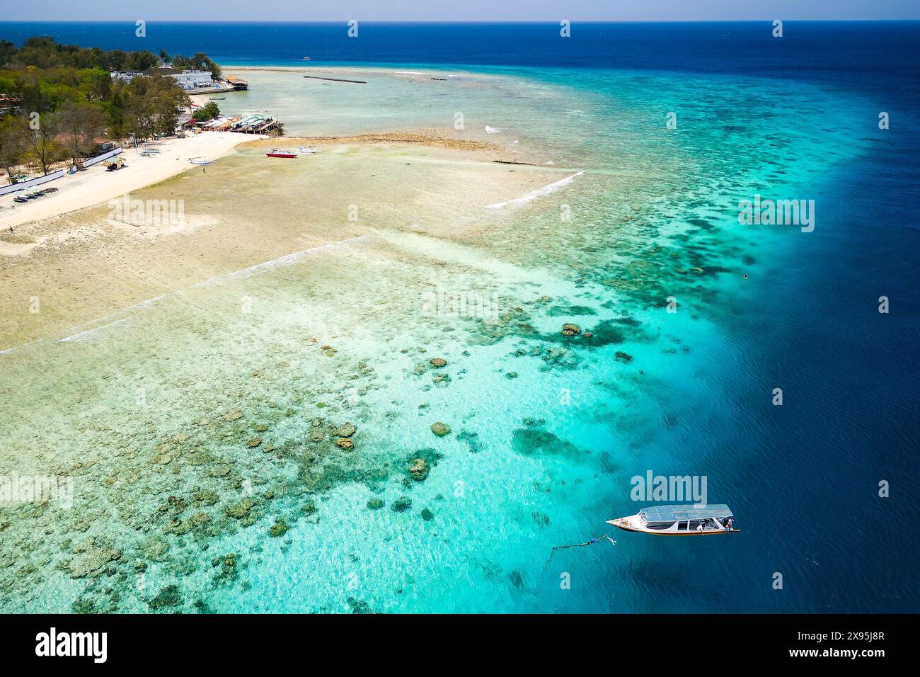 Snorkel and swim tour boats on the edge of a tropical coral reef off a ...