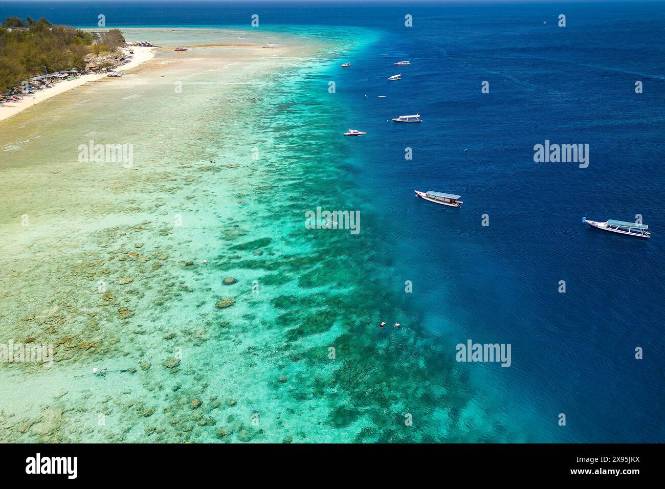 Snorkel and swim tour boats on the edge of a tropical coral reef off a ...