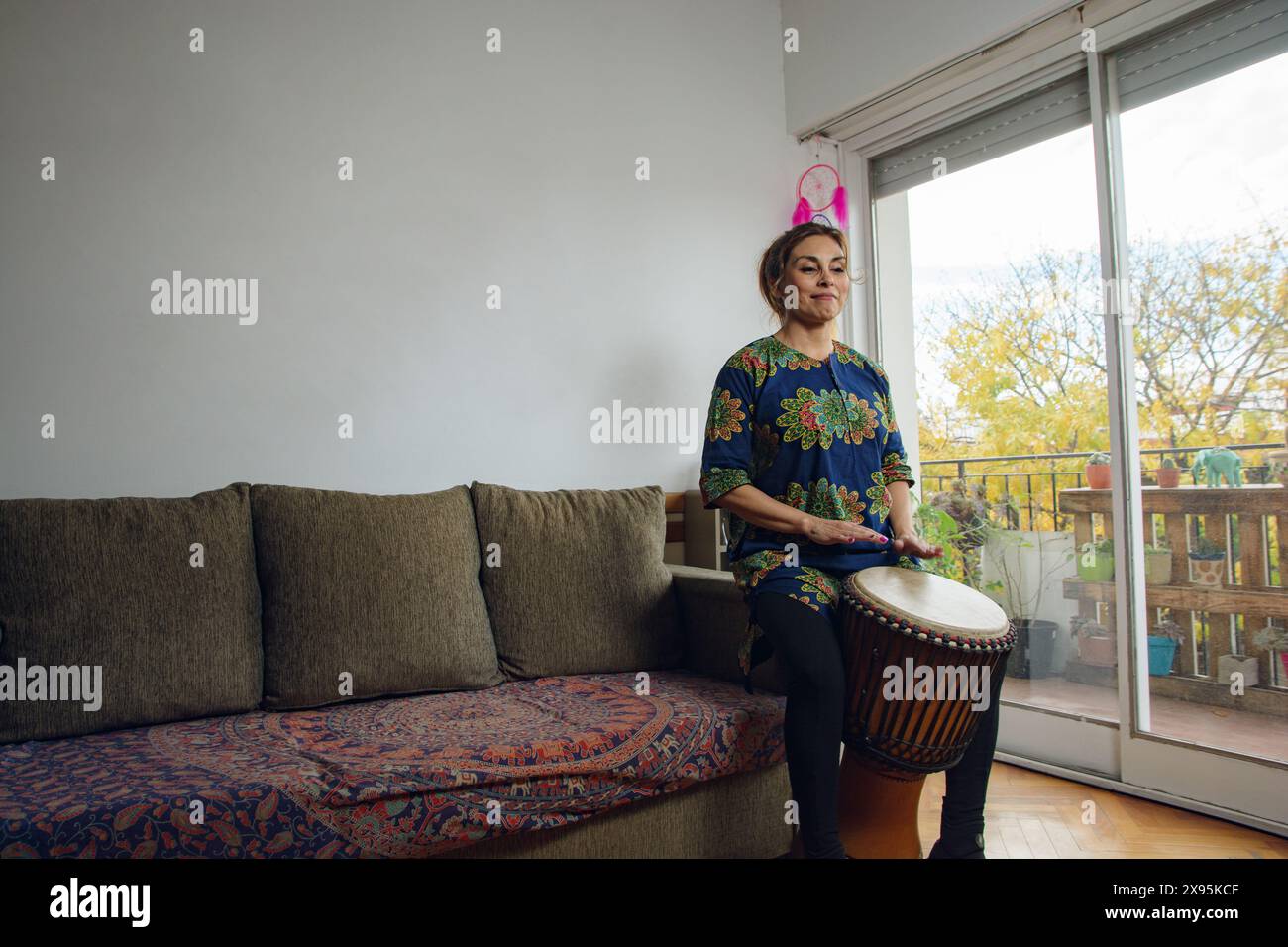 An Adult Woman sitting at home with the eyes closed inspired playing ...